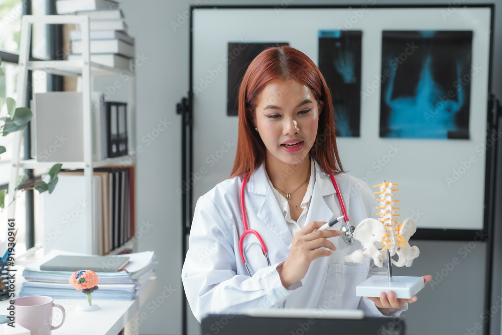 Female doctor explaining spinal anatomy to her online audience using ...