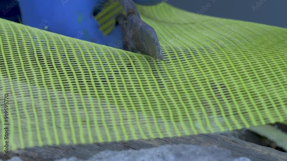 Contractor cuts fiberglass reinforcing plastering grid or mesh on ...