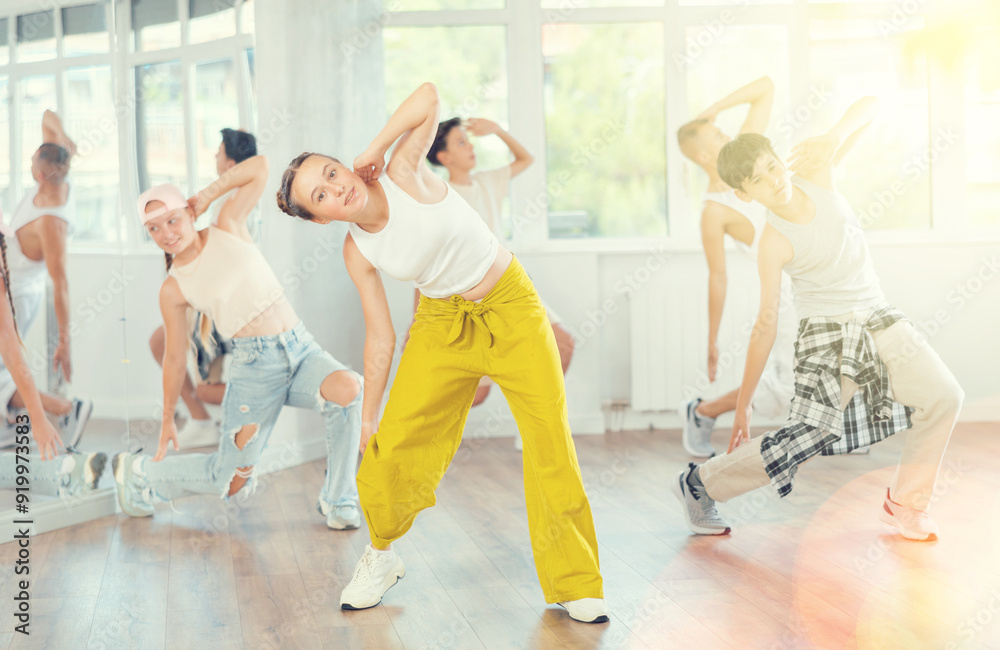 Positive teenage girl practicing hip hop backbend moves in training ...