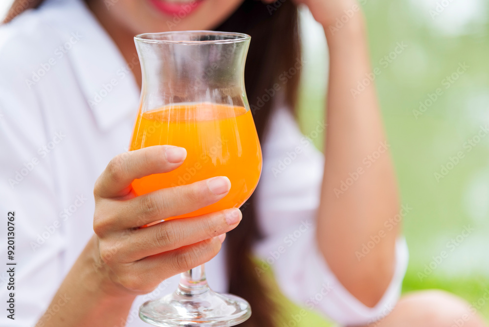 Women hands drink orange juice fresh fruit cool drinking in green park ...