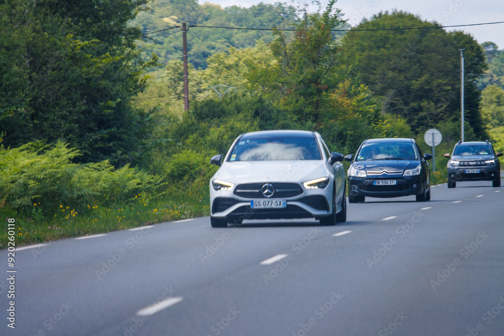 France, 1 July 2024: Mercedes-Benz leading a convoy of cars on a rural ...