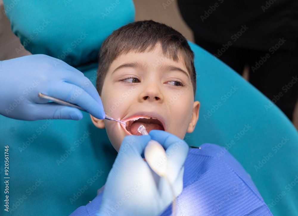kid in dental office. dentist checking child teeth using tools mouth ...