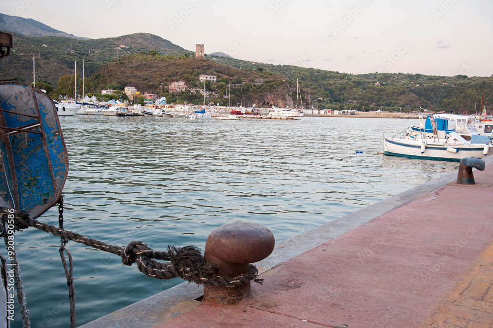 Rusty mooring bollards along the concrete wharf in the bay of Marina di ...