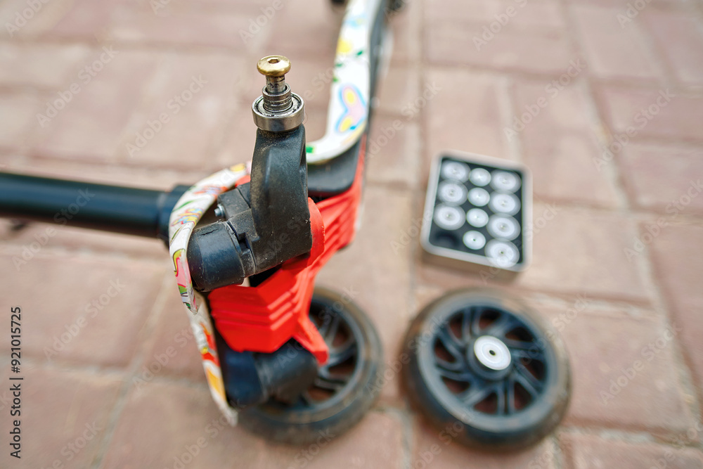 Broken scooter with detached wheel, damaged wheel bearing, front axle ...