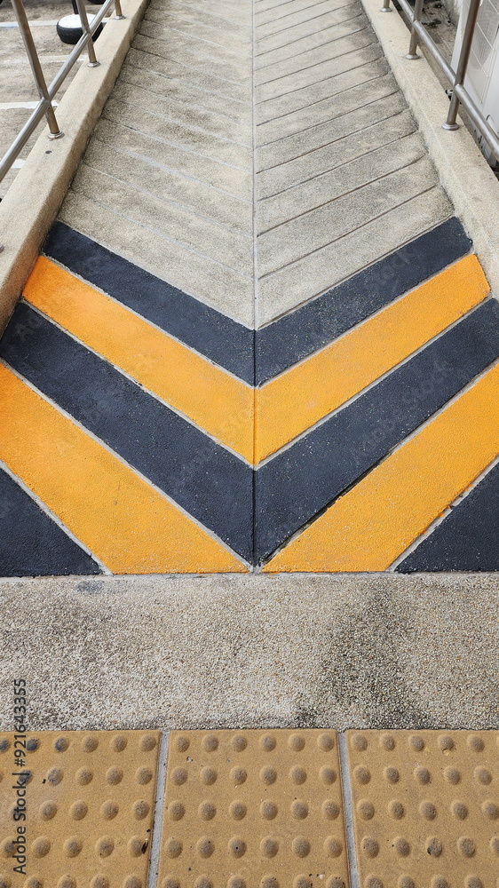 Wheelchair ramp. There are stainless steel rails on both sides, yellow ...