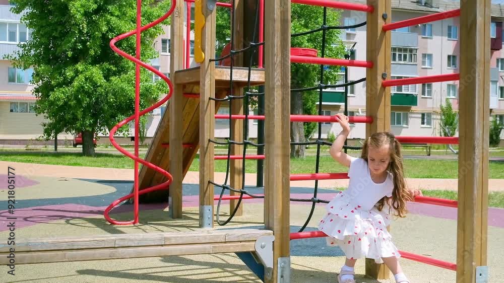 Upset crying baby girl on the playground at swing. Children playing ...