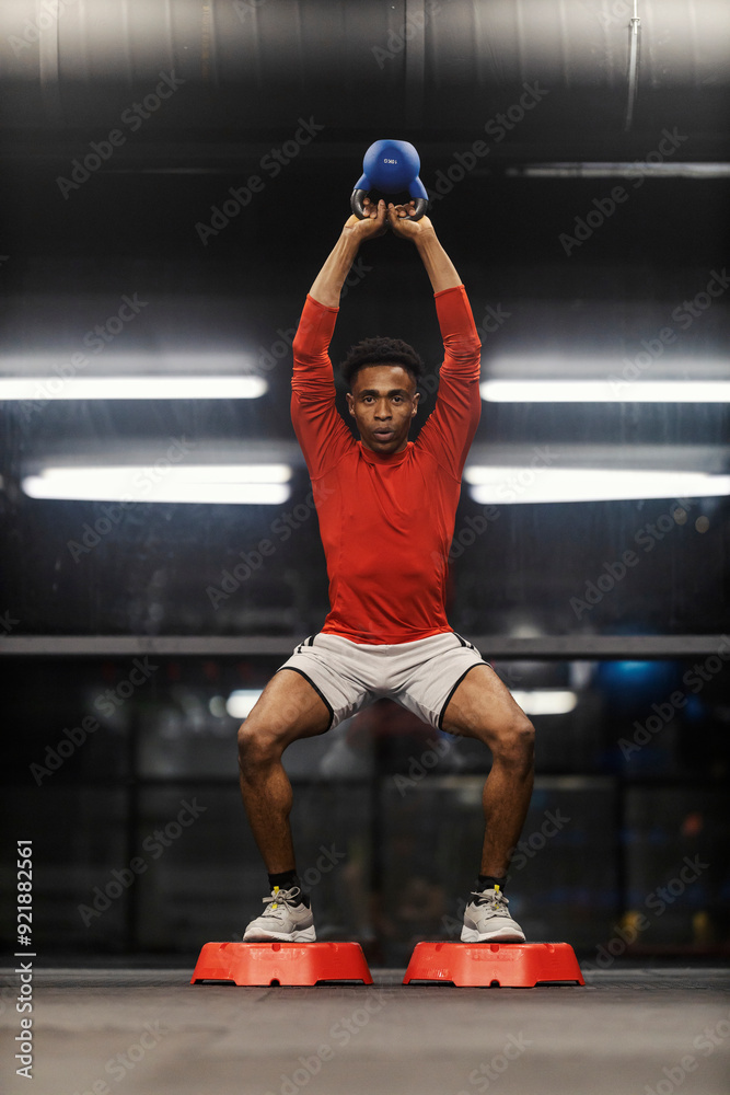 Front view of strong muscular black bodybuilder on steppers in ...