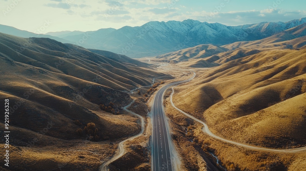 Aerial perspective of a long road leading through a mountain range with ...