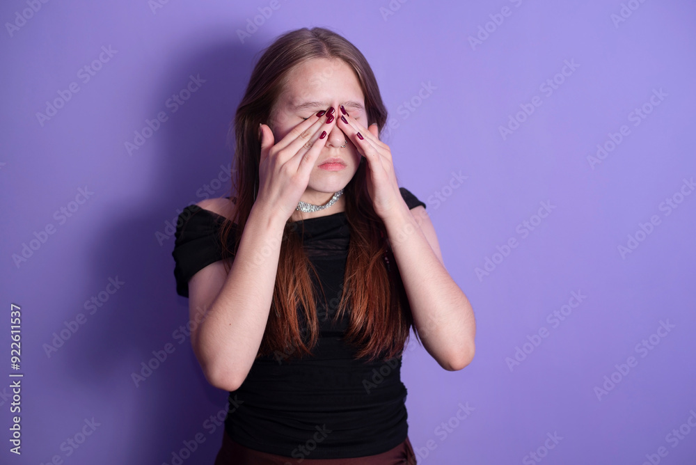 A young beautiful teenage girl is tired and closes her eyes, which hurt ...