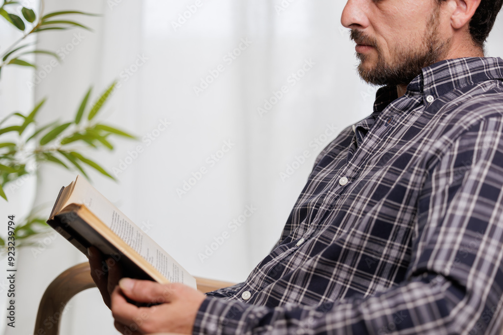 Young boy reading an interesting book. The young man entertains himself ...