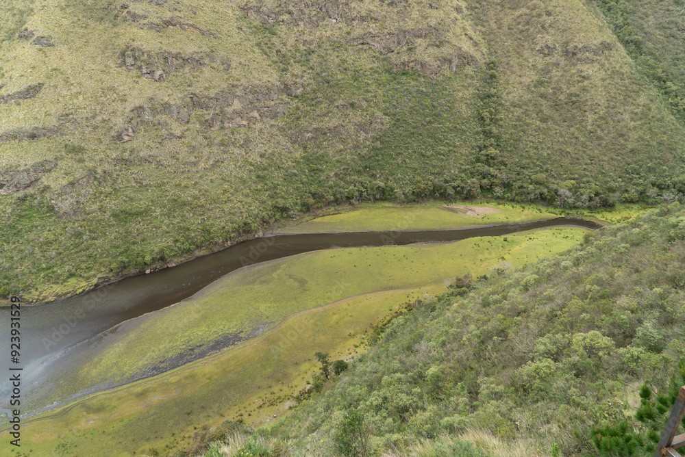 Top down bird's eye view of a small stream in a green hilly mountain ...
