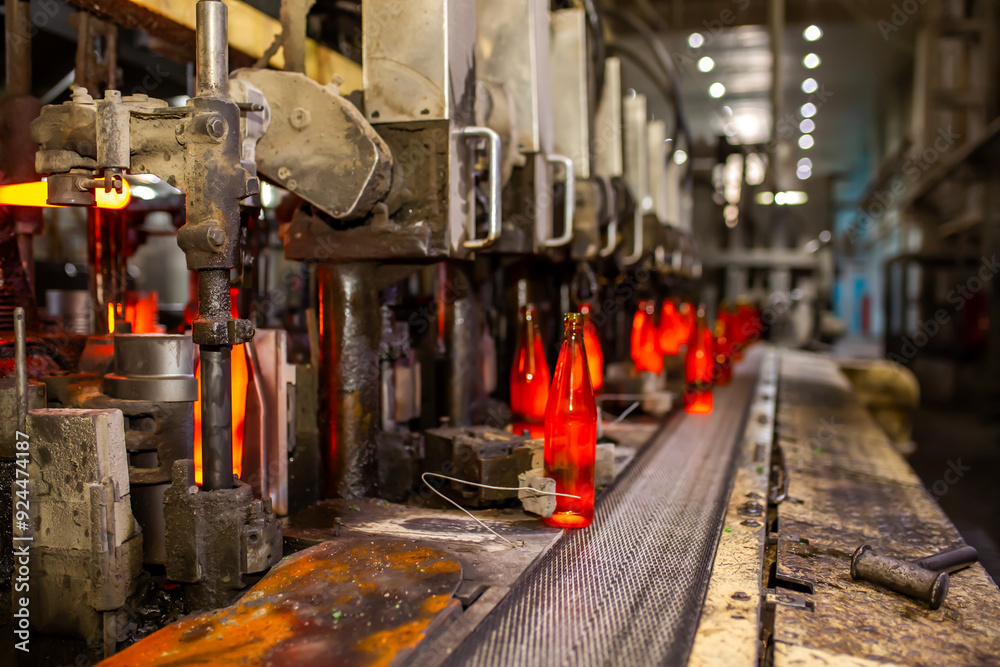 Glass factory, production of glass containers. Molten glass is blown ...
