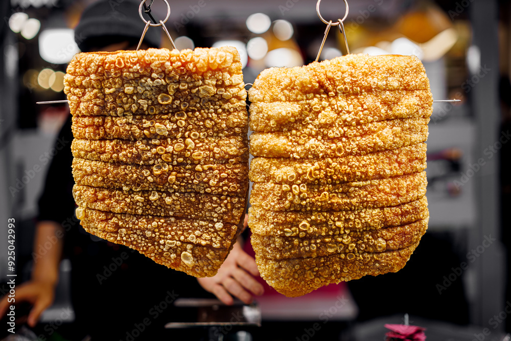 Close-up of crispy pork skin sale at a market. The golden, crackling ...