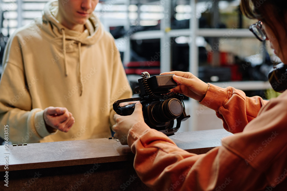 Man handling high-end camera equipment in a well-lit studio environment ...