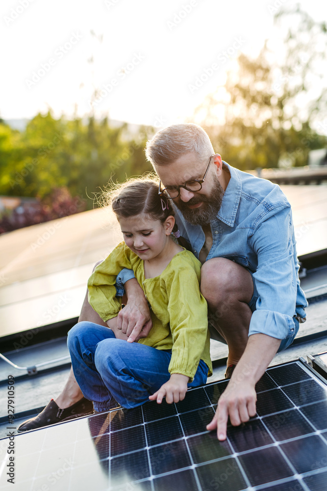 Dad and girl on roof with solar panels, learning about solar energy ...