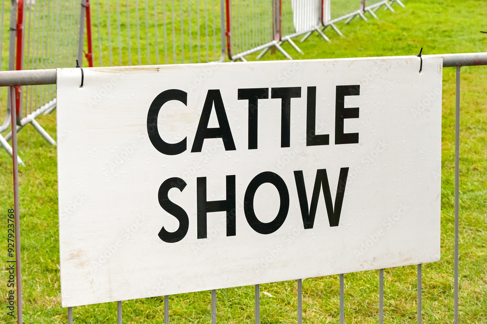 Sign at an outdoor agricultural event showing the arena for the cattle ...
