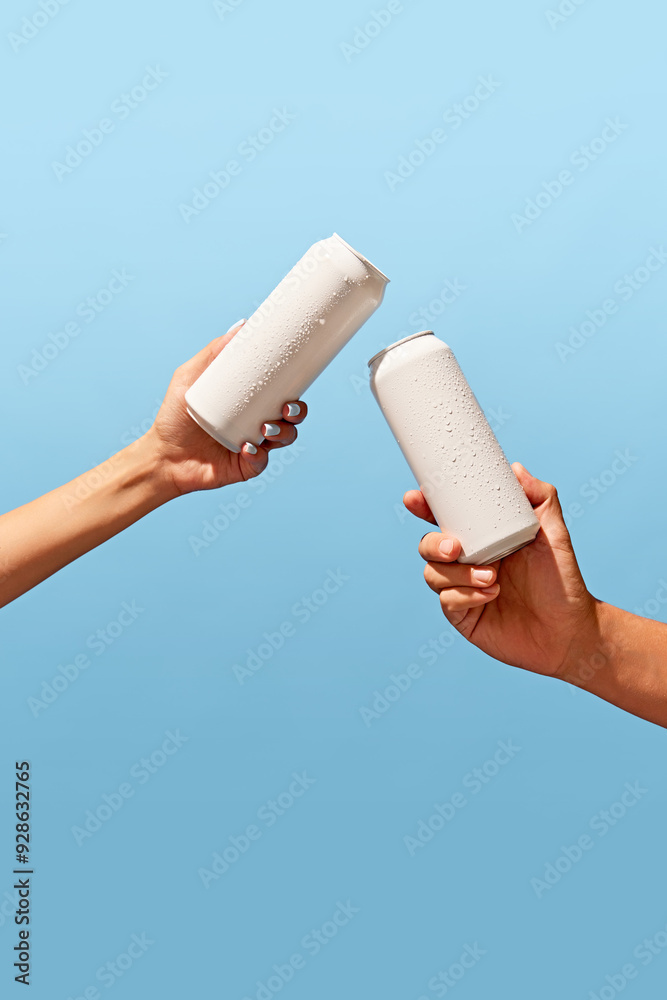 Cheers. People holding two white cans against light blue background ...