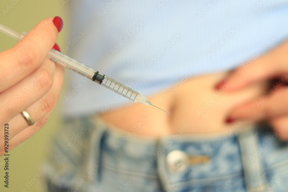 Insulin syringe. A woman with a syringe is about to inject herself with ...