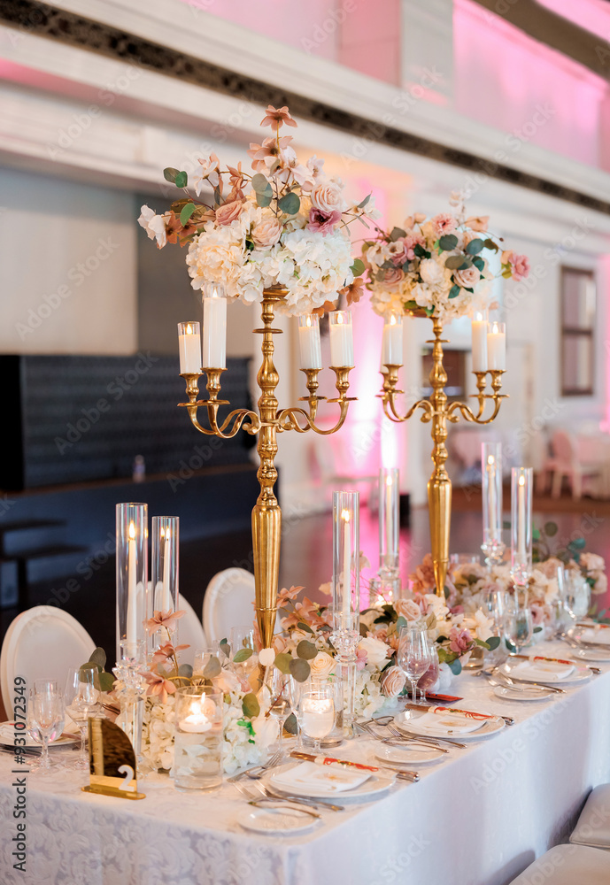 The table of the bride and groom decorated with gold candlesticks and ...
