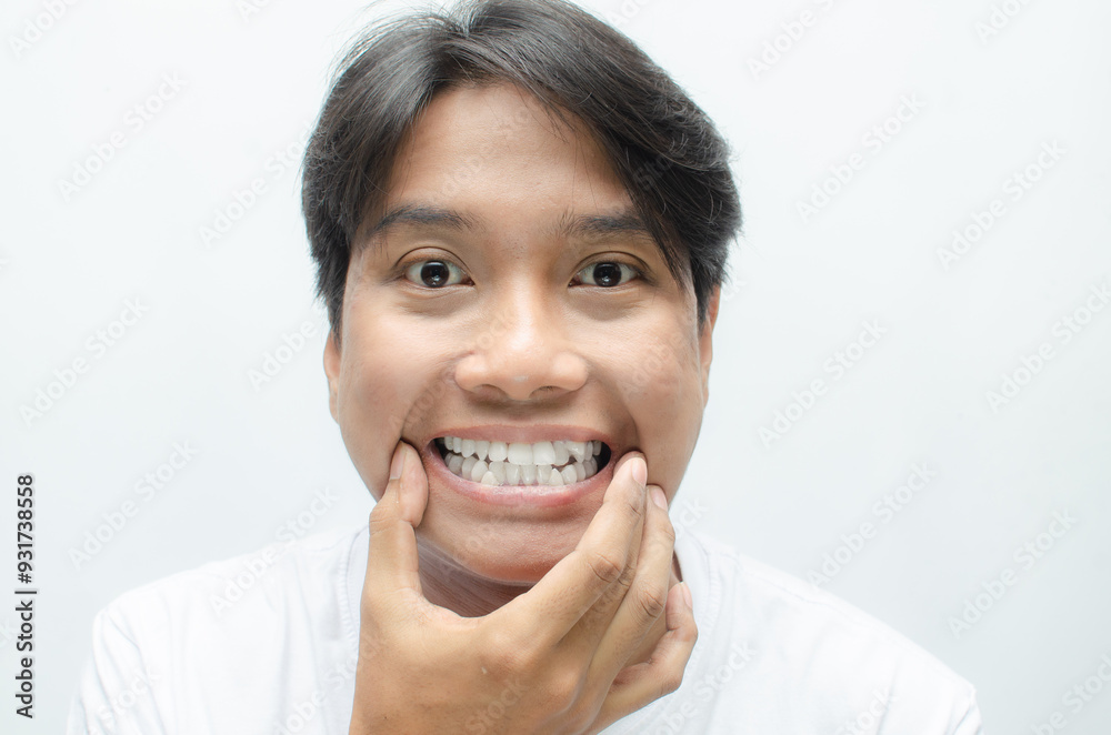 young asian man smiling and showing his crooked teeth isolated over ...