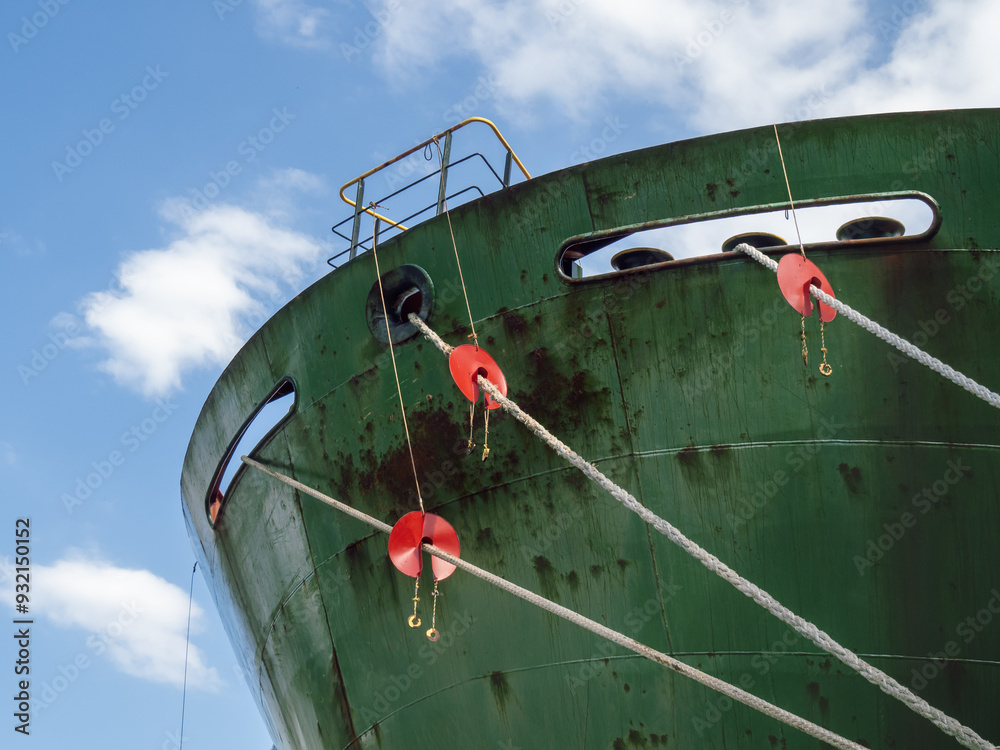 Red ocean ship rat guards on the mooring lines of a vessel to keep ...
