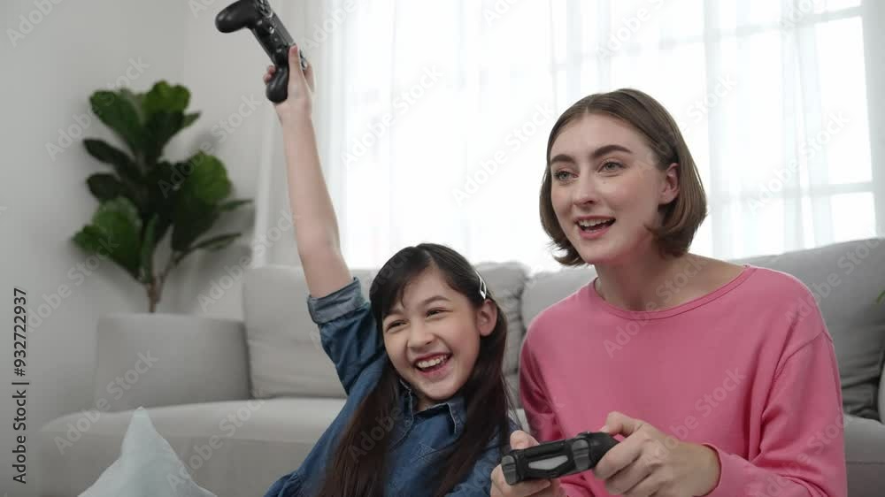Girl winning game while caucasian mom clapping hands to celebrate ...