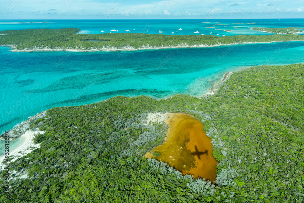 Aerial photo looking down at the airplane's shadow and clear tropical ...