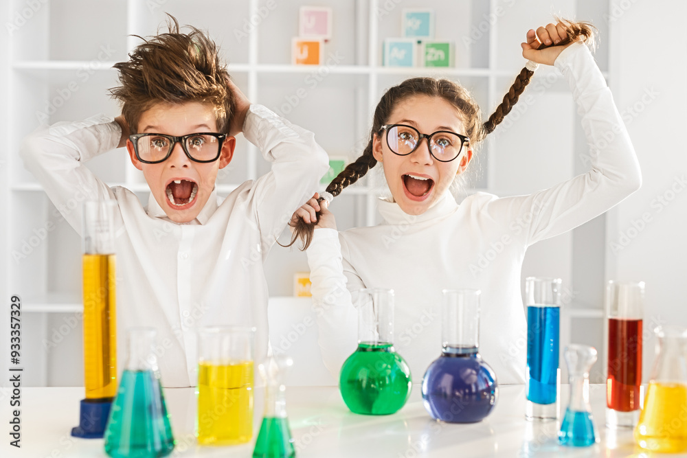 Two enthusiastic children in a chemistry class experimenting with ...