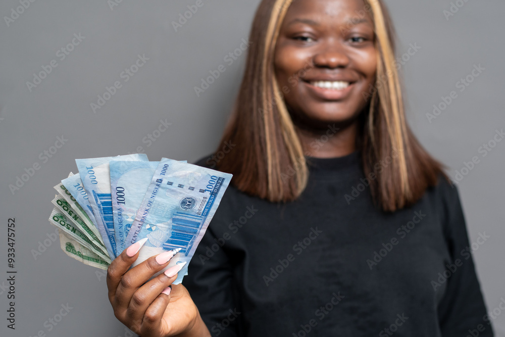 Beautiful young black woman holding some money and smiling Stock Photo ...