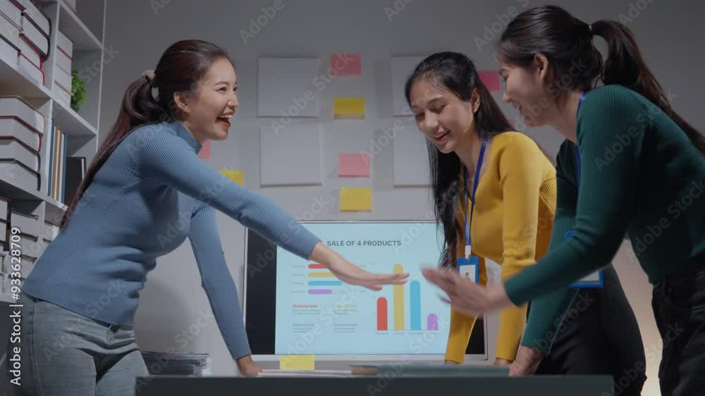 Three asian businesswomen are celebrating achieving positive sales ...