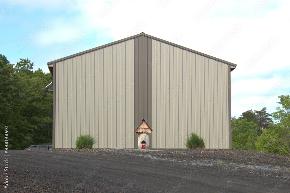 Side of an industrial building with a log statue in front that is ...