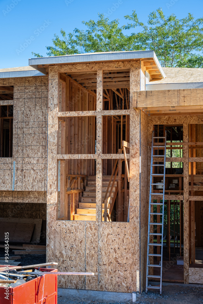 New large residential home construction in framing stage, with exterior ...