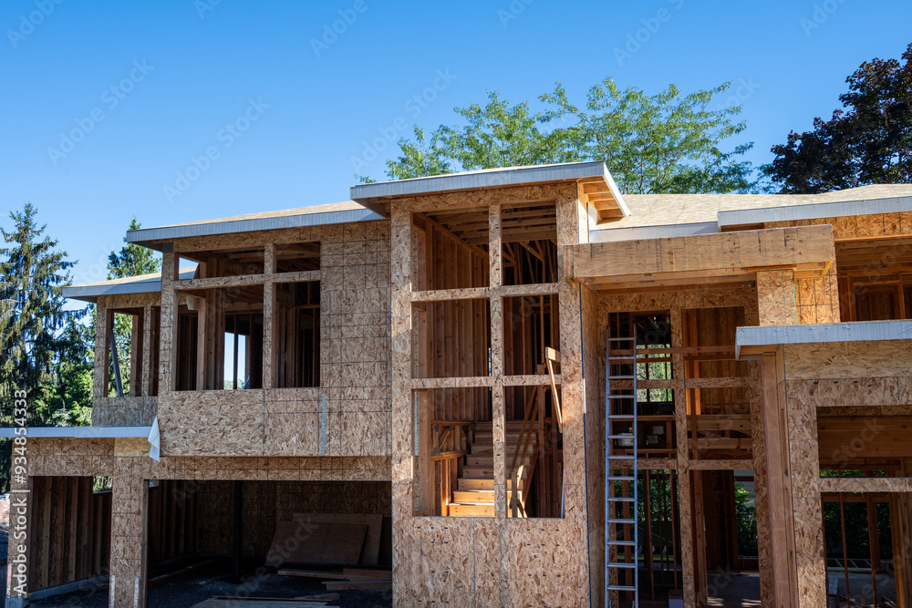 New large residential home construction in framing stage, with exterior ...