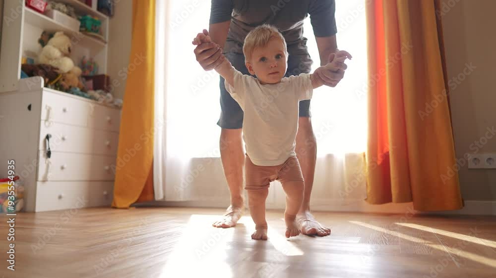 Daddy and baby taking the first steps. Child-father concept. A baby is taking the first steps on ...