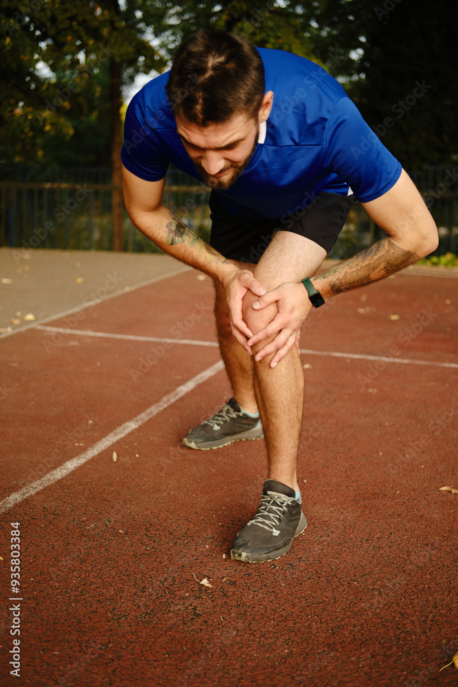 Knee Pain. Sports injury. Young man has knee pain during outdoor ...