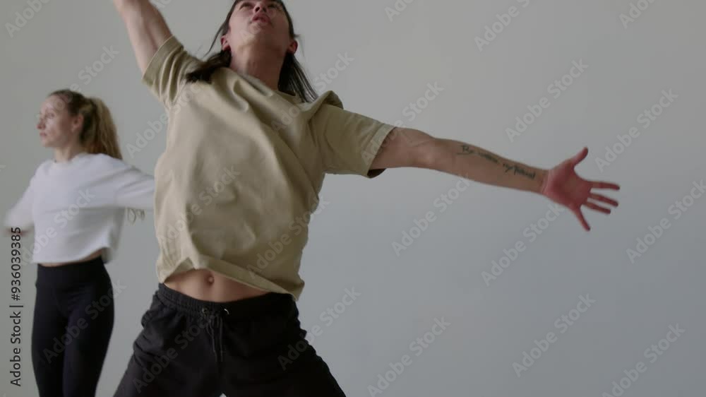 Muscular male dancer performing torso circles in plie squat, female ...