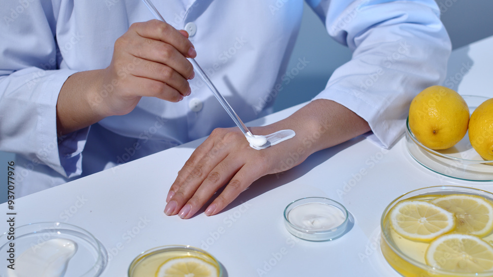 A scientist is seen smearing cream on a table alongside lemons and ...