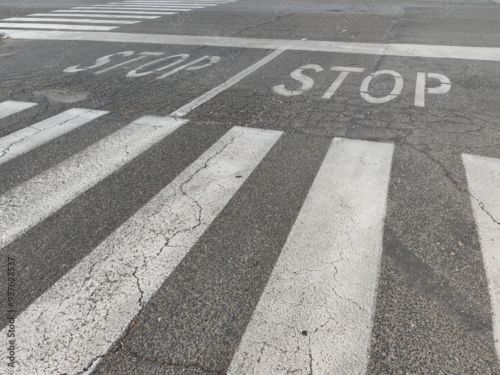Detail of a crossing with pedestrian crossings and a stop sign for cars ...