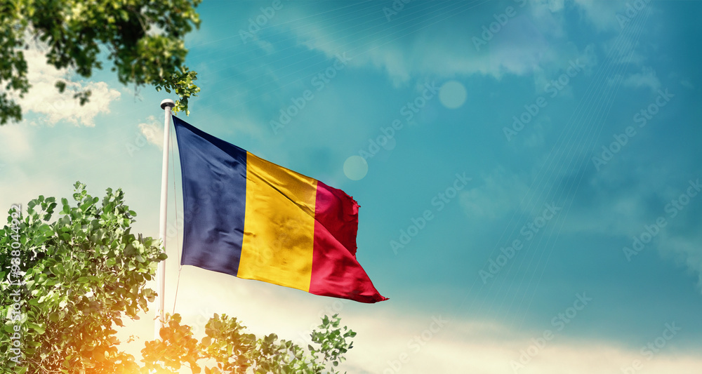 Chad national flag waving in the sky behind the tree. The flag blowing ...