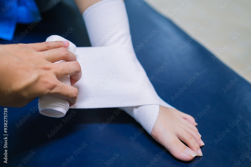 Patient with ankle sprain foot injury wrapping bandage over the ankle ...
