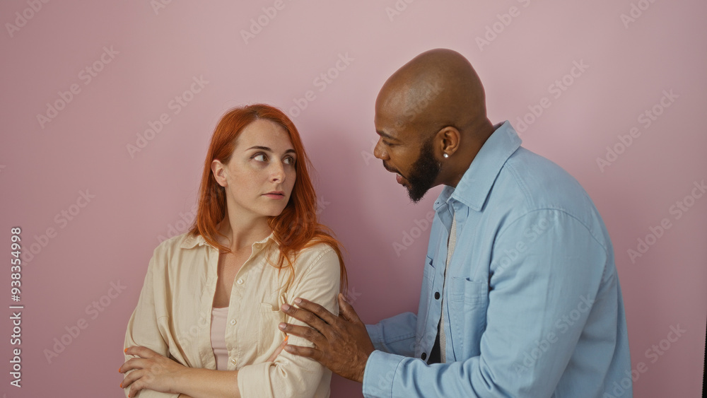 Interracial couple stands against a pink background with the man ...