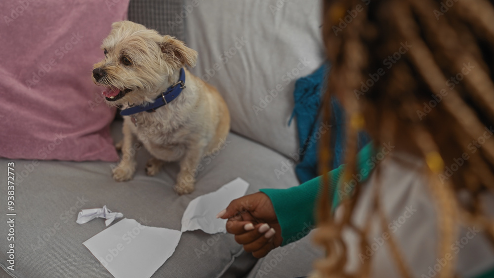 An african-american woman scolds her small dog in the living room for ...