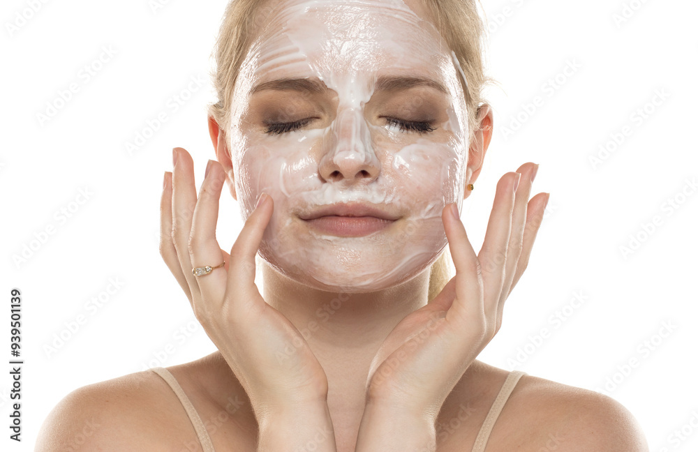 Beautiful young woman posing with a facial mask on her face. Skin care ...