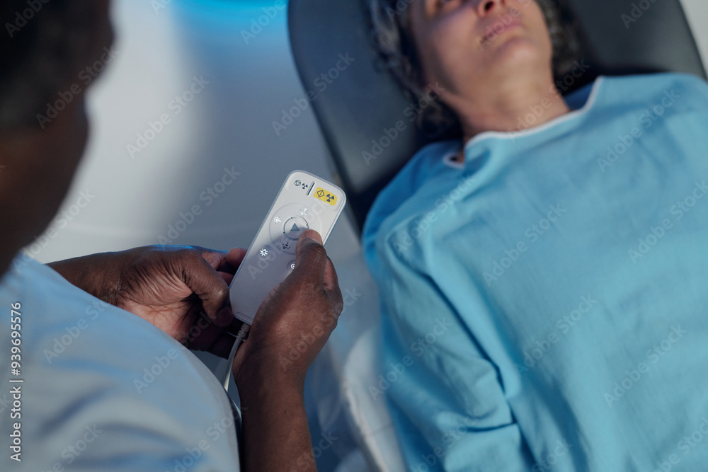 Medical professional adjusting bedside control panel in hospital room ...