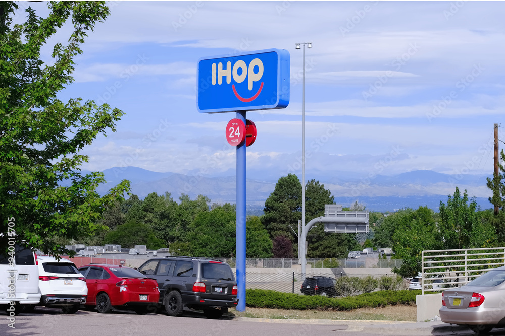 IHOP sign with a 24-hour indicator stands tall in a parking lot with ...