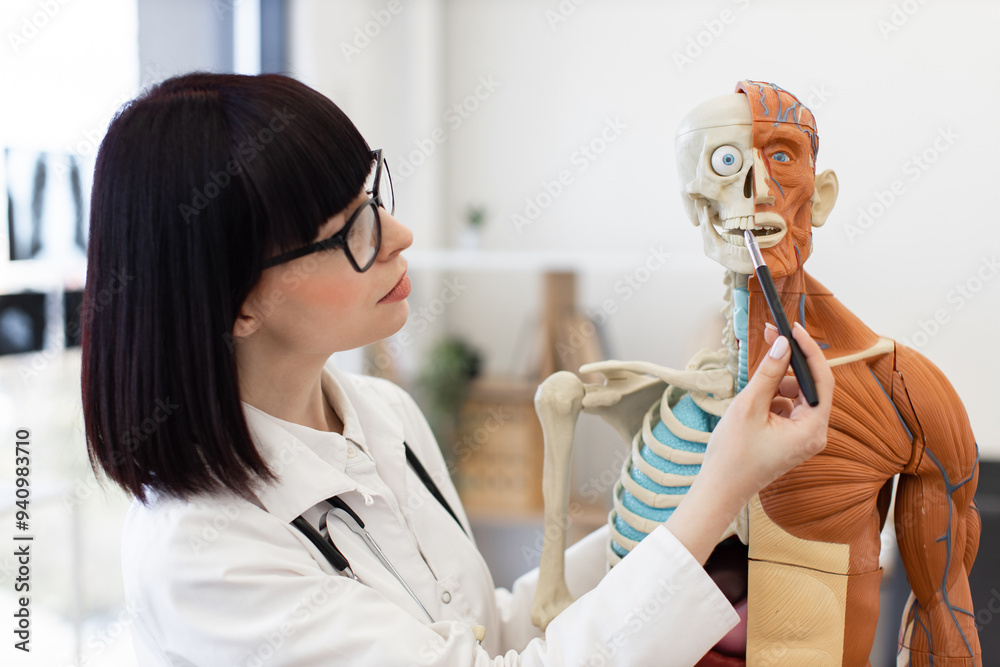 Female doctor explaining anatomy to medical students using human ...