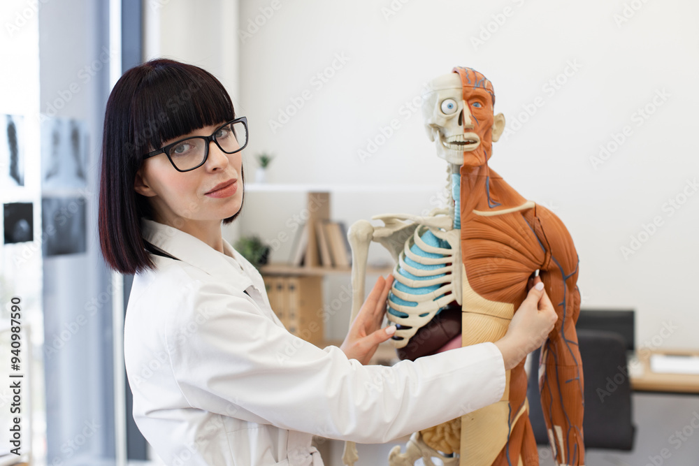Female doctor demonstrating anatomical model of human body in medical ...