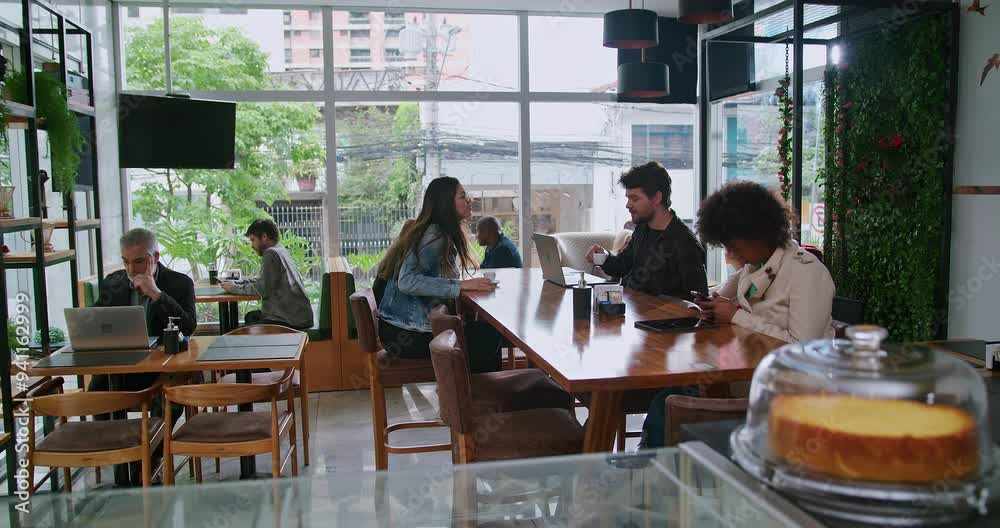 People working and socializing in a modern coffee shop with a mix of ...