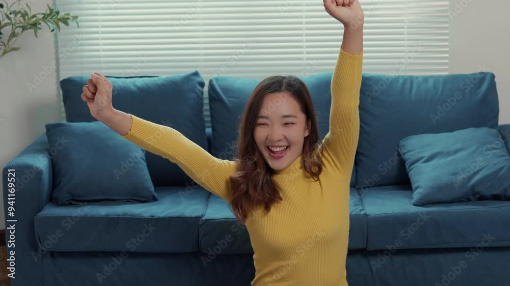 Joy radiates from a young woman sitting on the living room floor ...