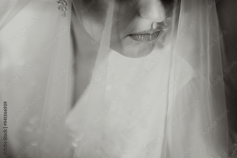 A woman is wearing a veil and looking at the camera. The veil is white ...